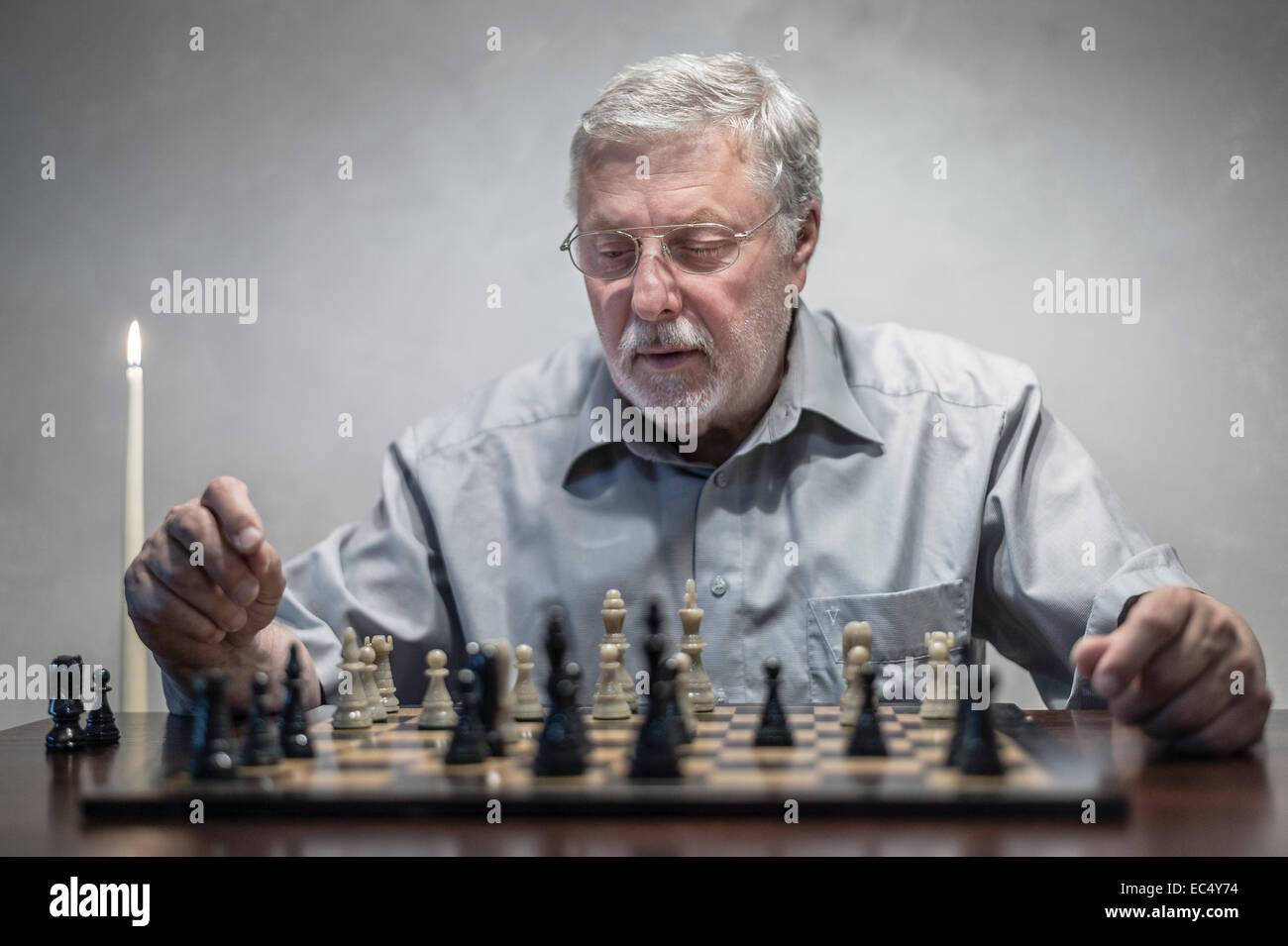 a senior citizen sitting at a table and look at the situation on a ...