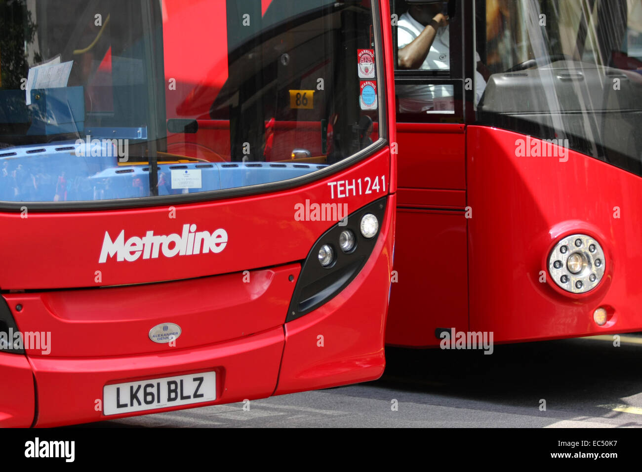 The front of two red London buses waiting at traffic lights in Oxford ...