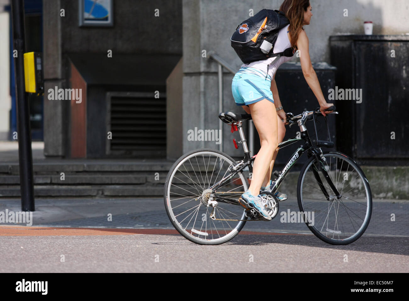 A female cycling along a road in London Stock Photo - Alamy