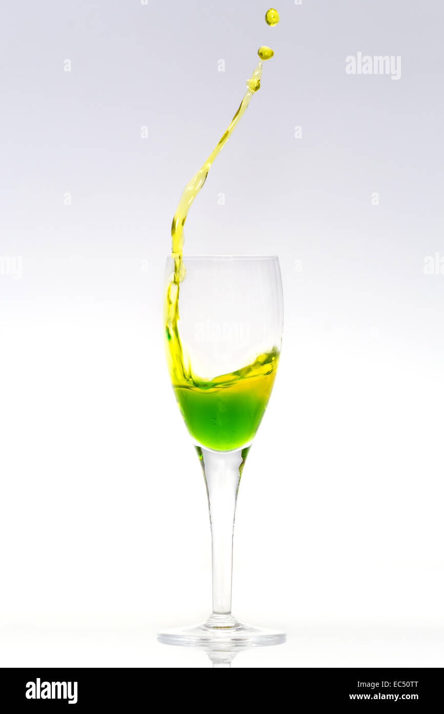Green and yellow liquid is splashing out of a glass Stock Photo - Alamy