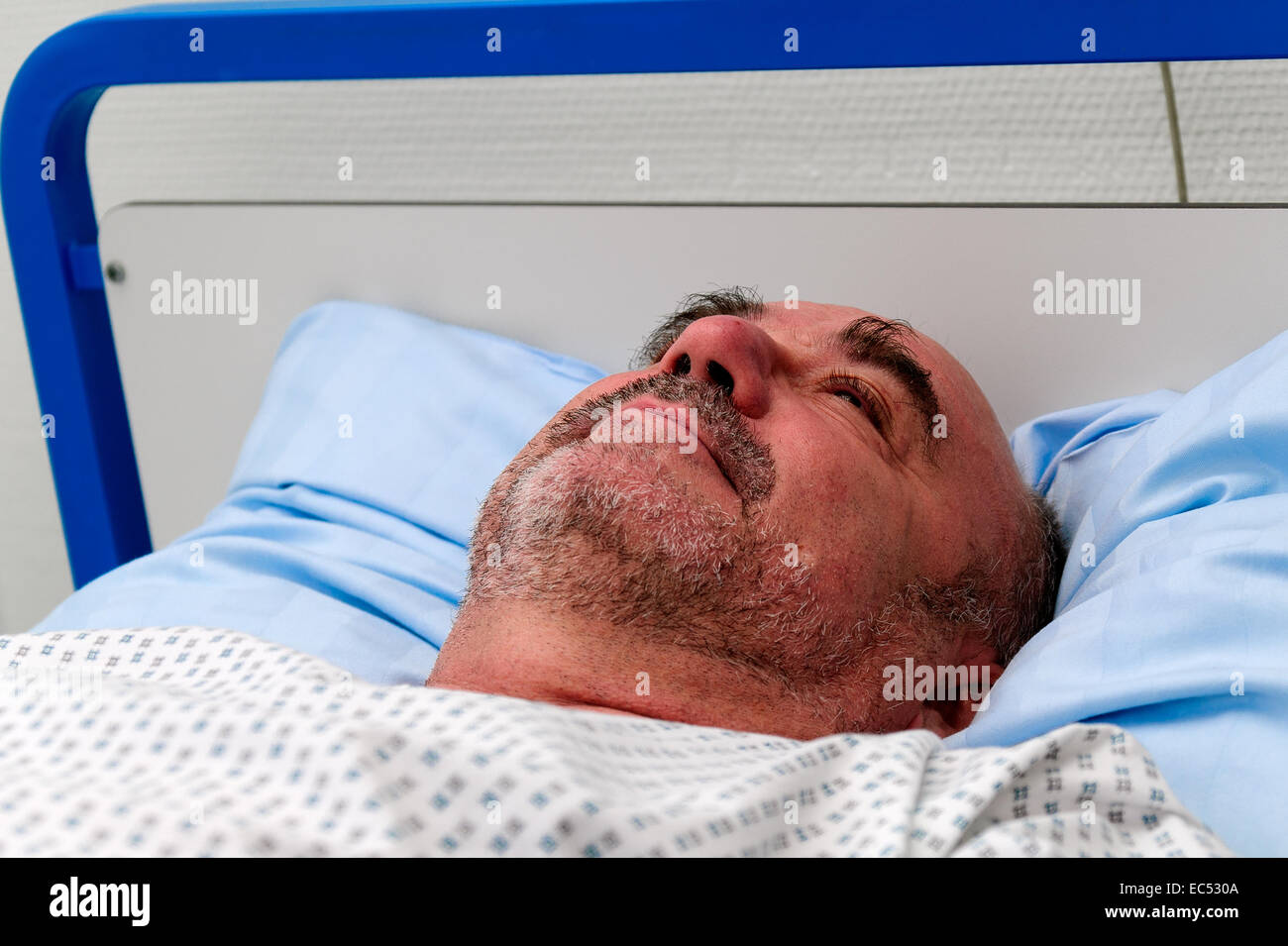 Man lying in a hospital bed Stock Photo - Alamy