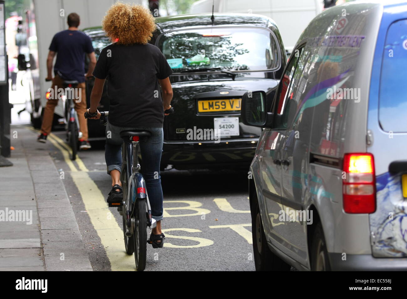 Cyclists traveling on the left of a queue of traffic in London Stock ...