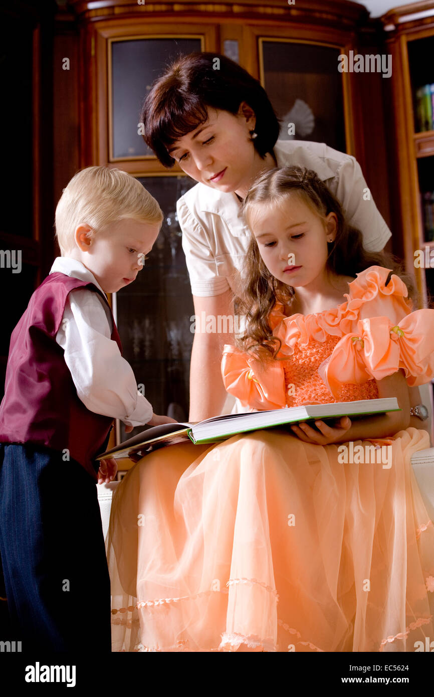 mother and children reading story-book Stock Photo - Alamy