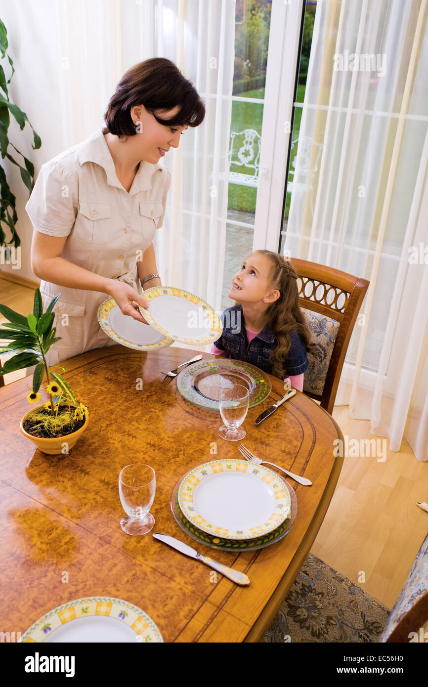 daughter and mom setting the table for a meal Stock Photo - Alamy