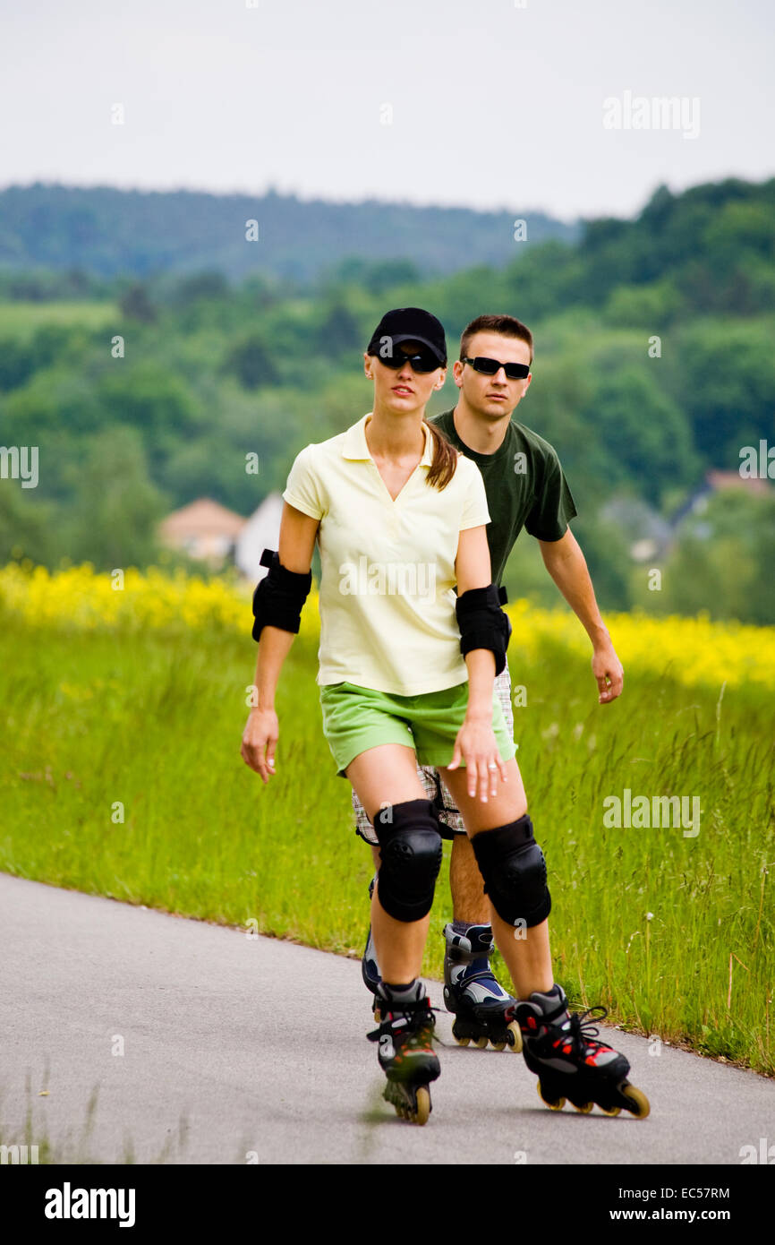 a couple ride rollerblades in the park Stock Photo - Alamy