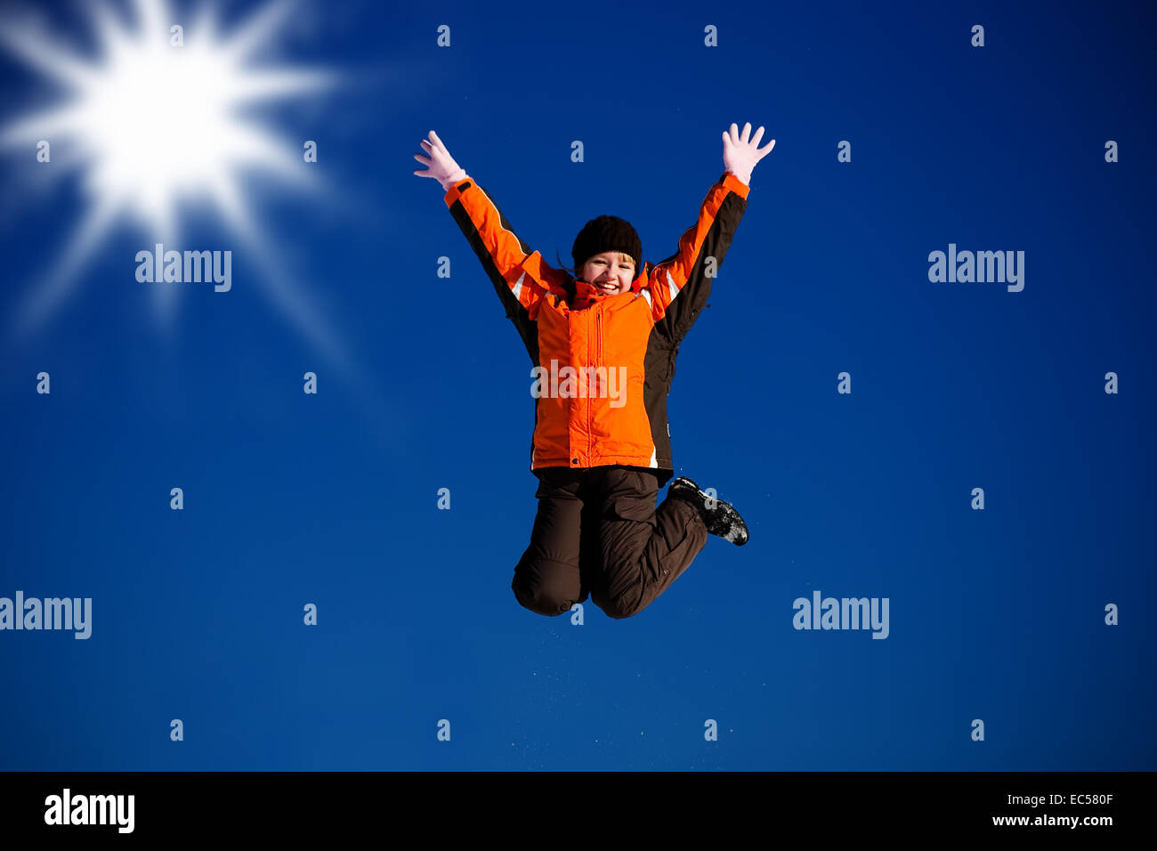 winter activities a girl jump by sledding downhill Stock Photo - Alamy