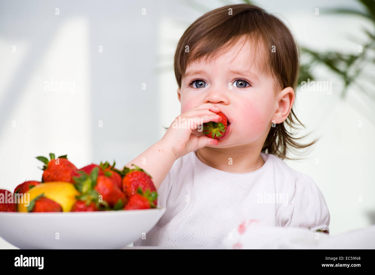 a little girl eating strawberries Stock Photo - Alamy