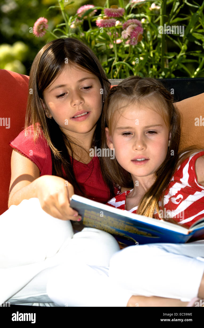 girls reading a book in the garden Stock Photo - Alamy