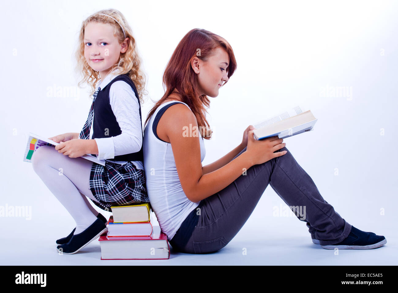schoolgirls with the books in front of white background Stock Photo - Alamy