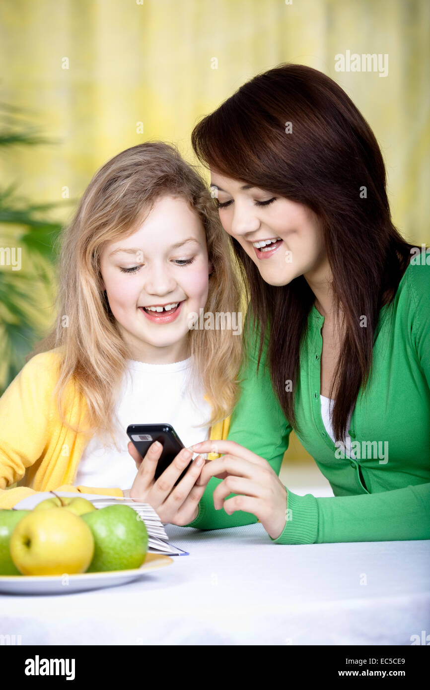 two girls with a cellphone at home Stock Photo - Alamy