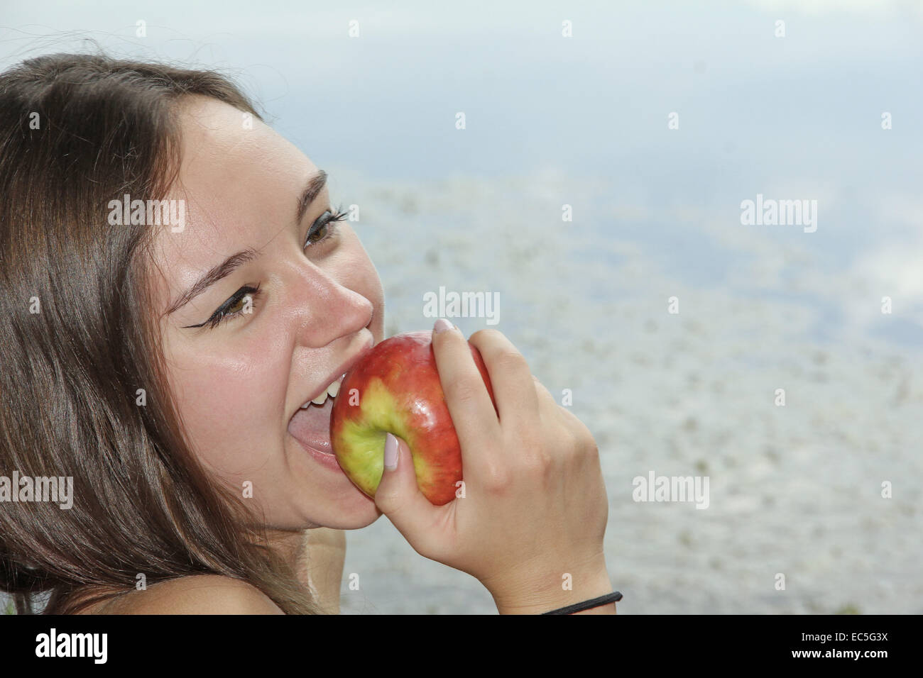 Young woman biting into apple Stock Photo - Alamy