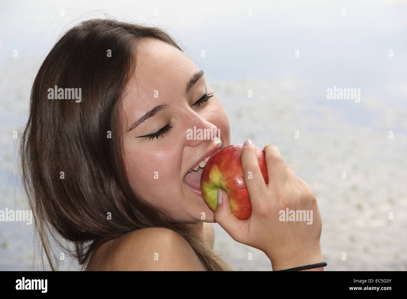 Young woman biting into apple Stock Photo - Alamy