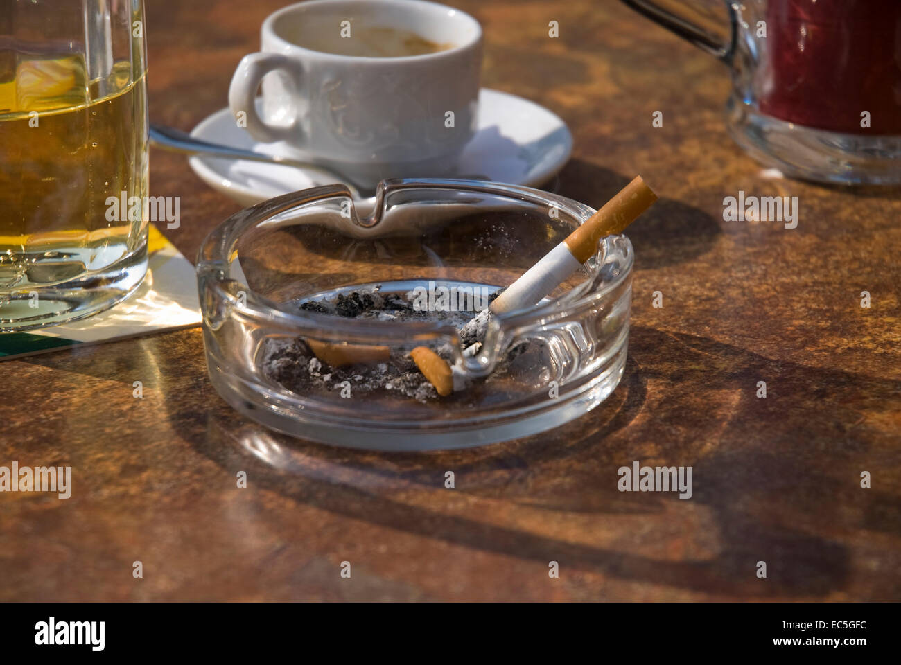 burning cigarette in an ashtray on a table in a restaurant Stock Photo ...