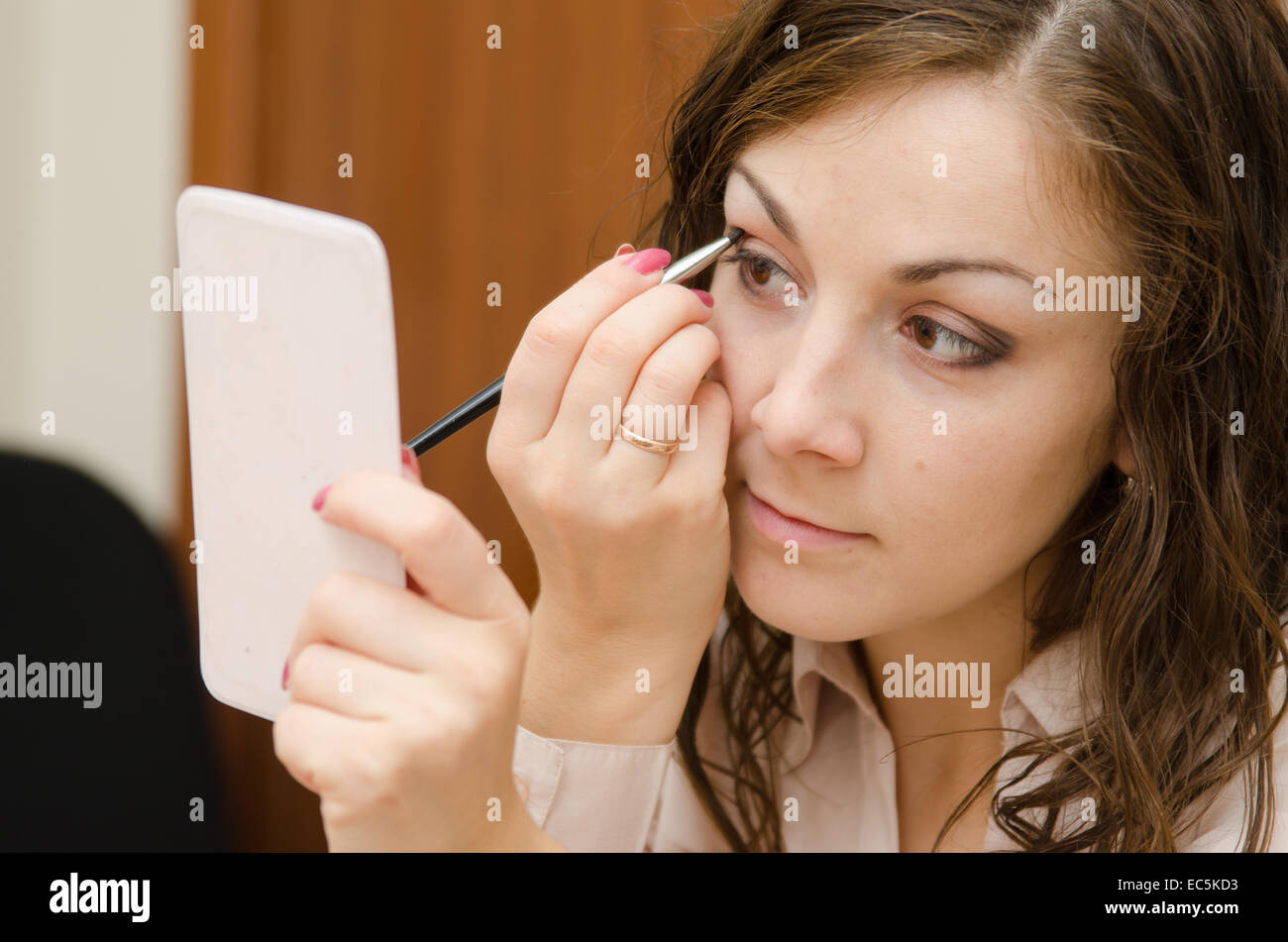A young girl puts makeup in the office workplace Stock Photo - Alamy