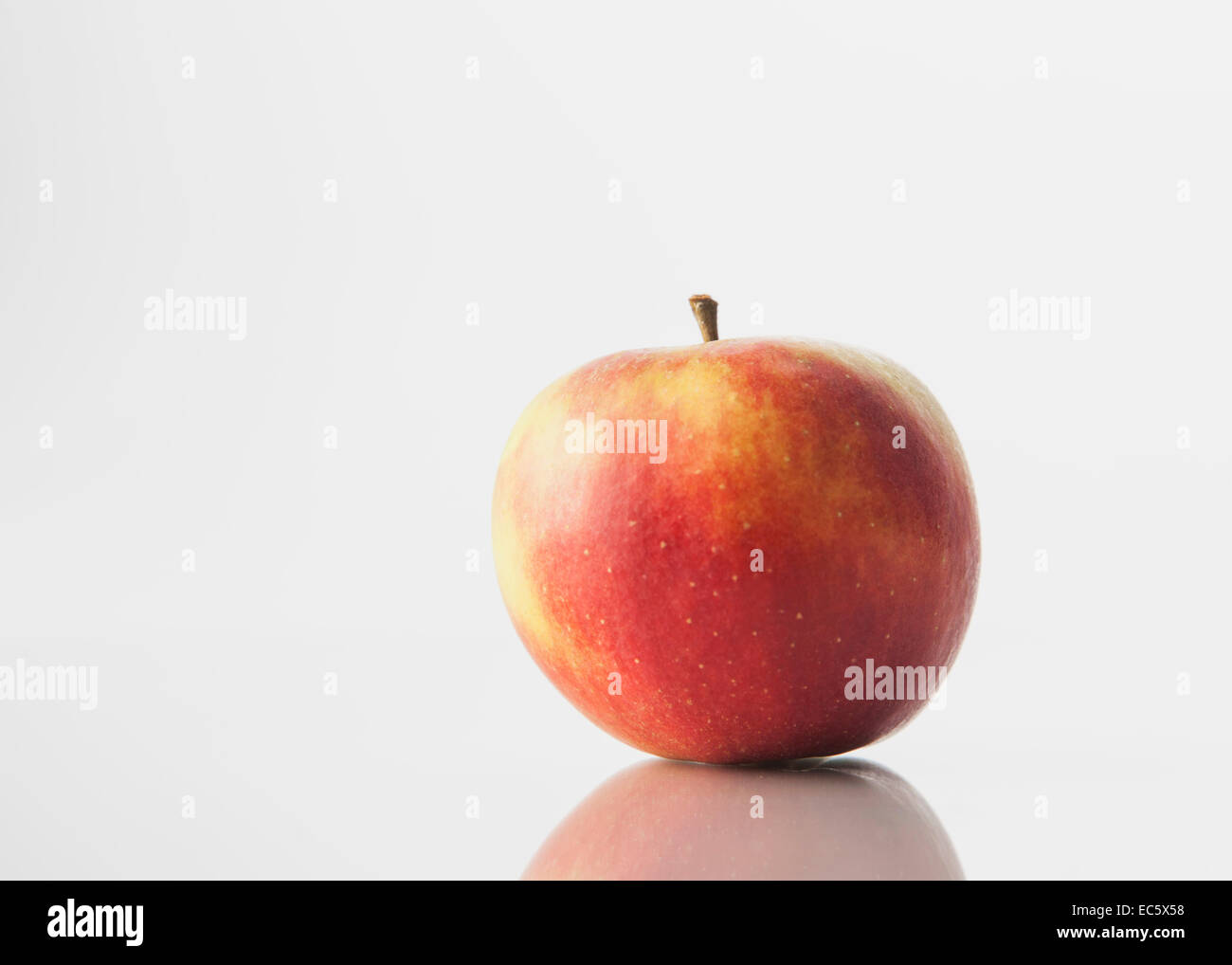 a single apple against white with a reflection Stock Photo - Alamy