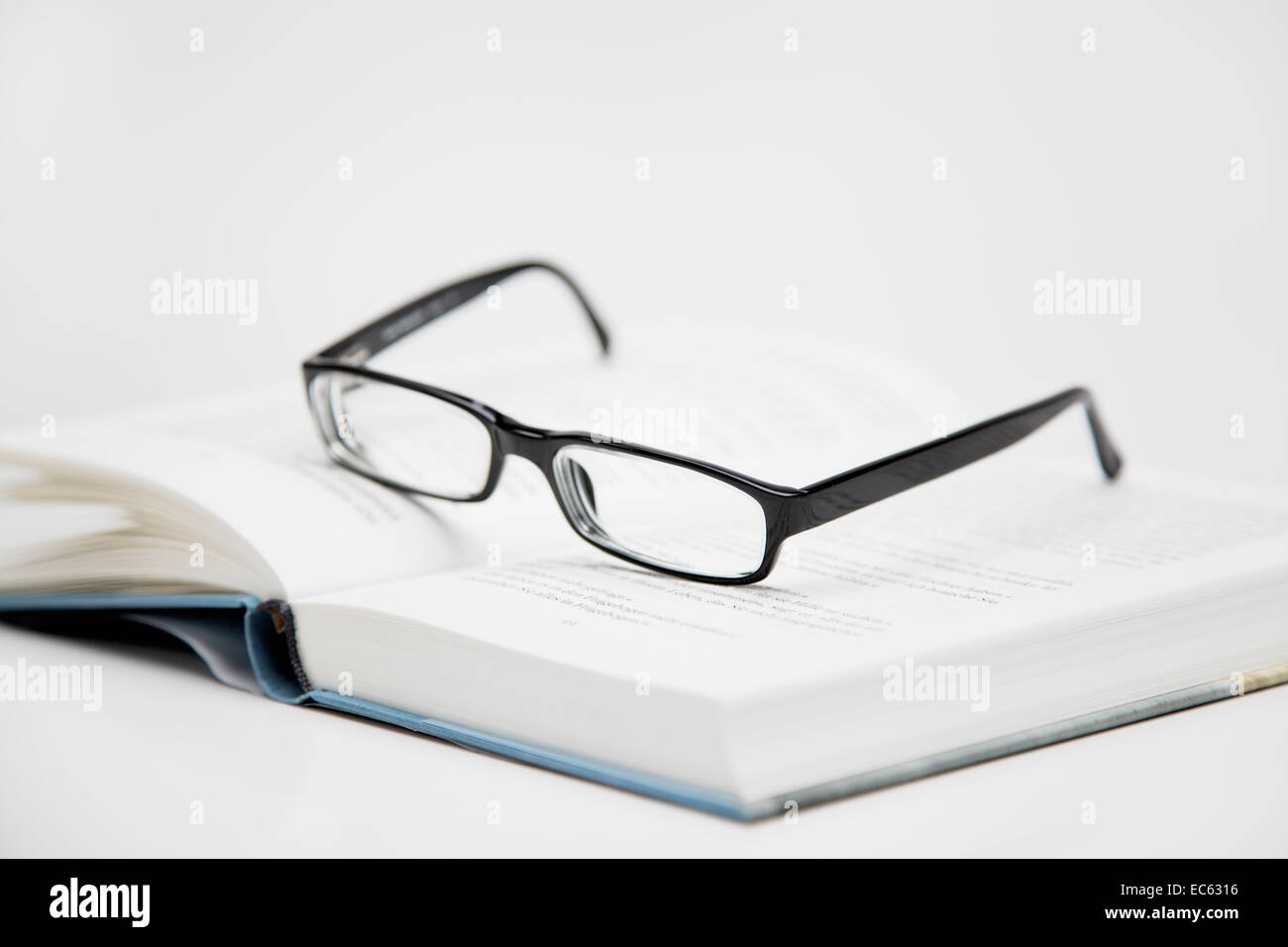 Glasses on a book Stock Photo - Alamy