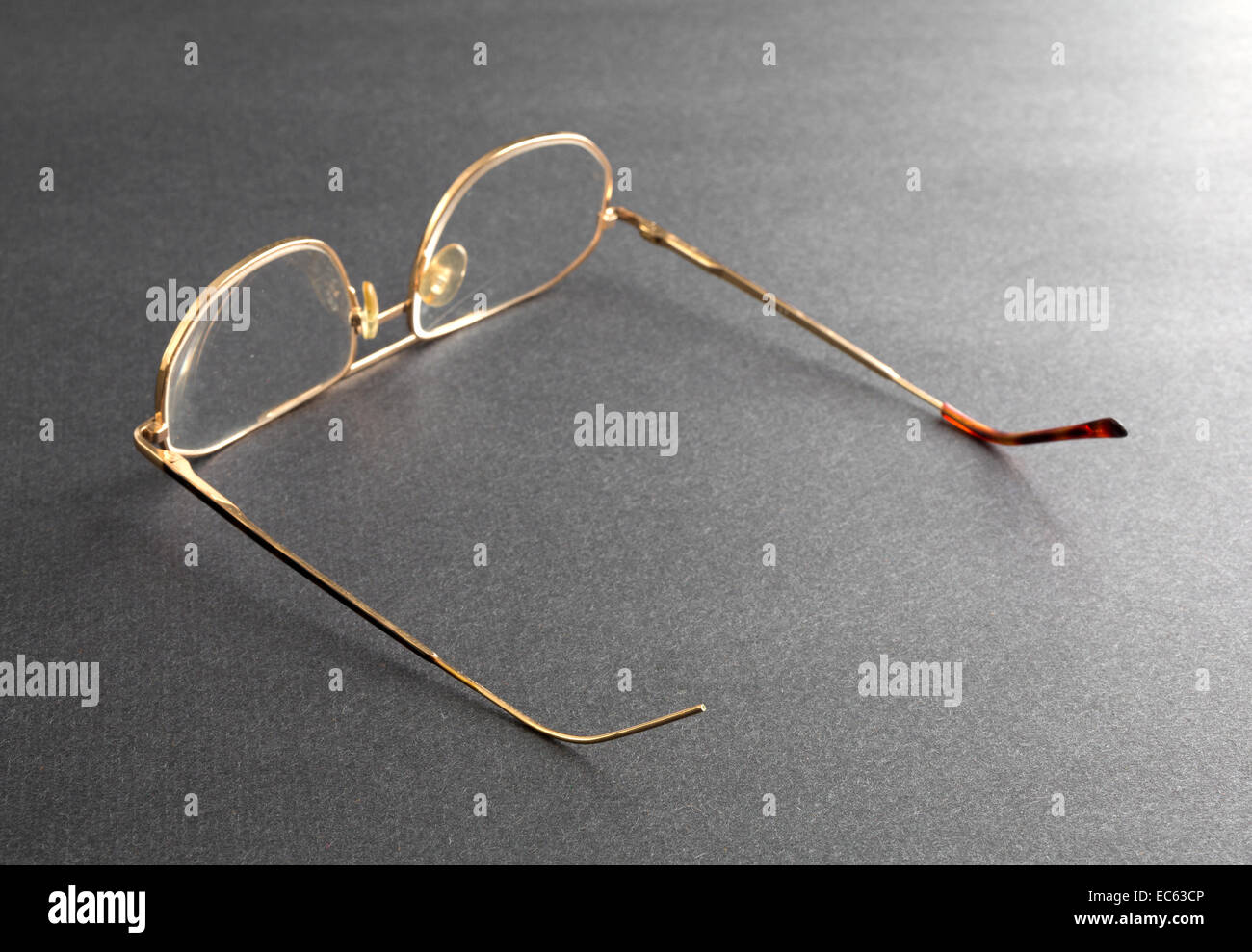 A pair of old plastic lens eyeglasses that are missing one temple tip ...