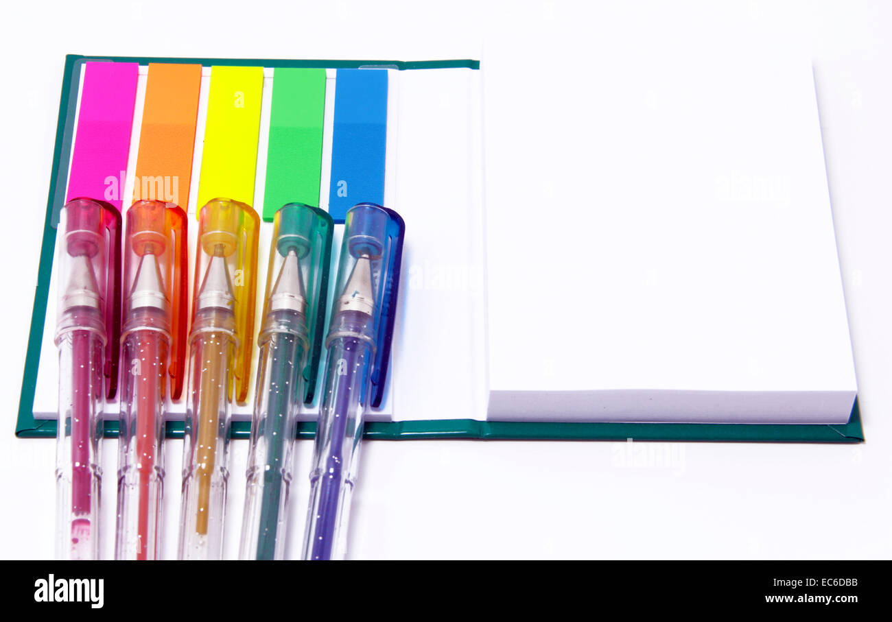 Colored pencils and a note on white background Stock Photo - Alamy