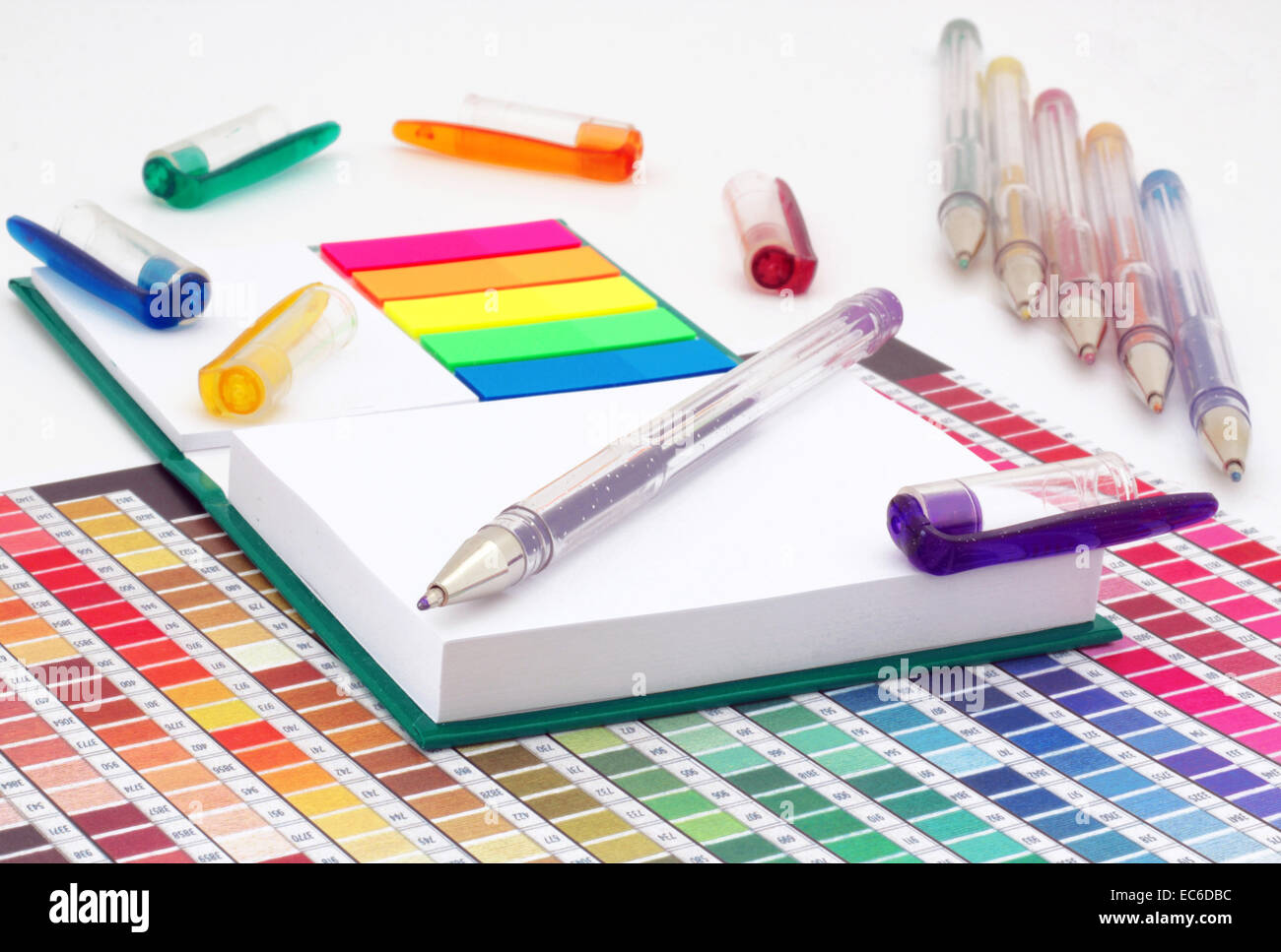 Colored pencils and a note on white background Stock Photo - Alamy