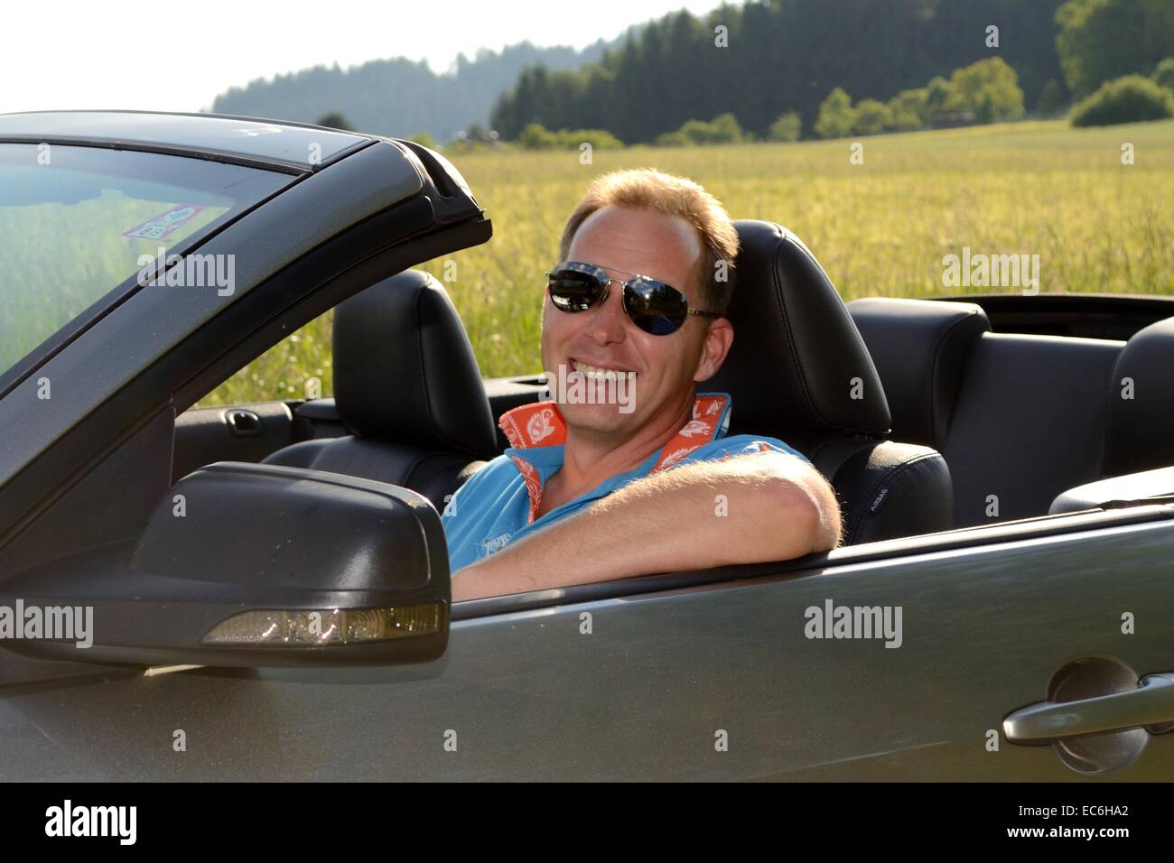 Convertible driver friendly smiles from the car Stock Photo - Alamy