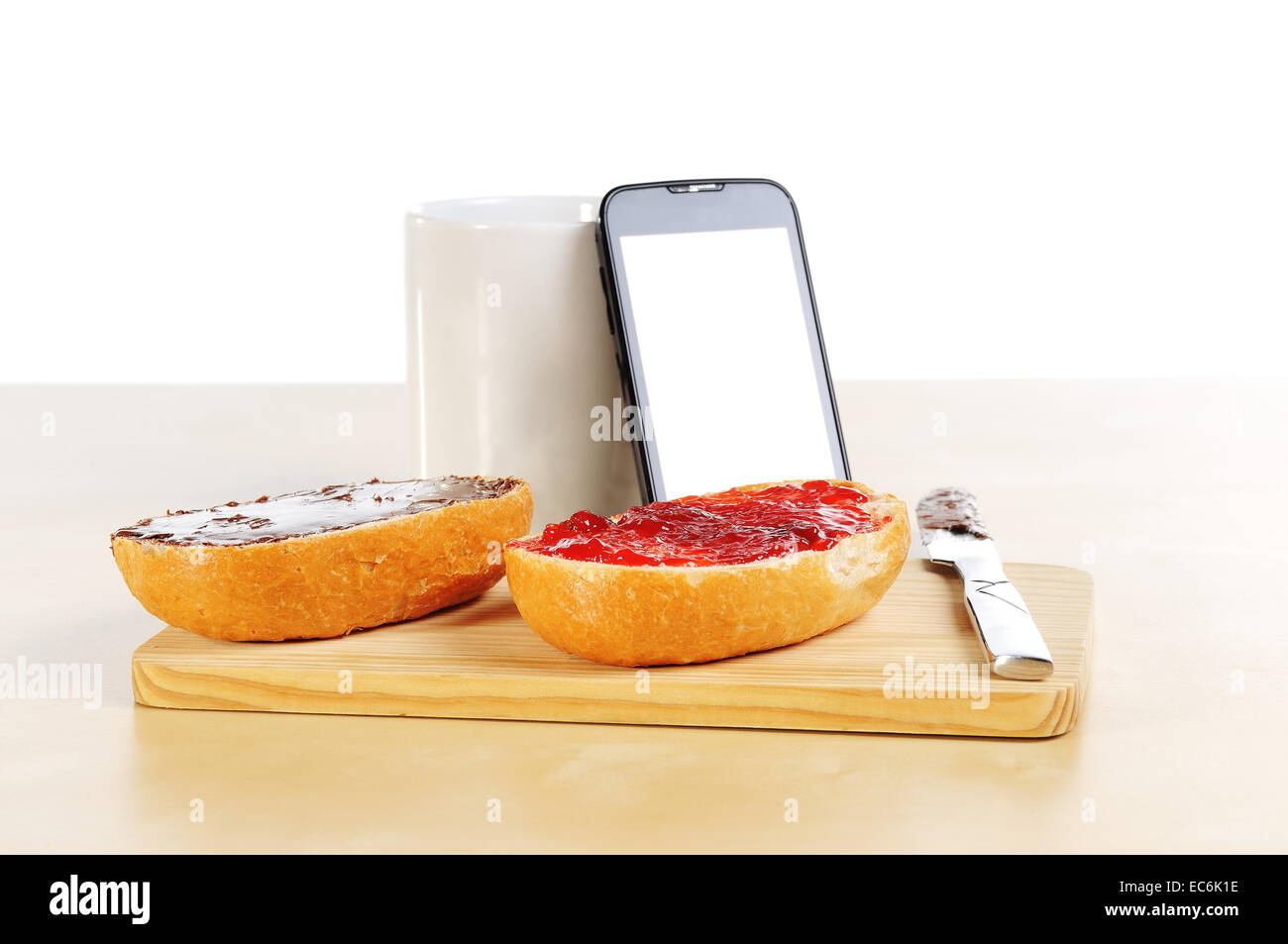 bread rolls with hazelnut cream and marmelade, mobile phone an coffee ...
