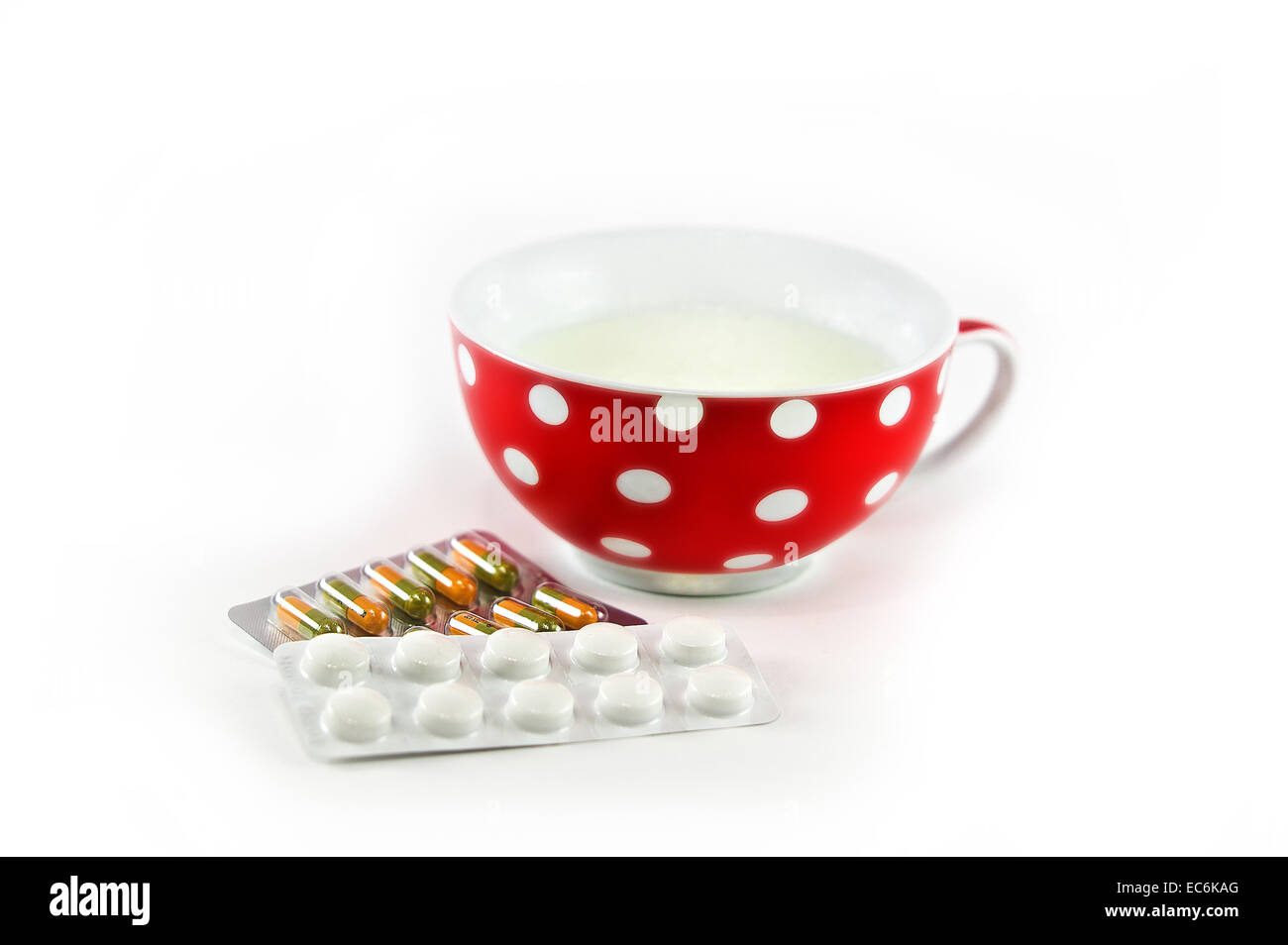 red cup with milk and tablets Stock Photo - Alamy