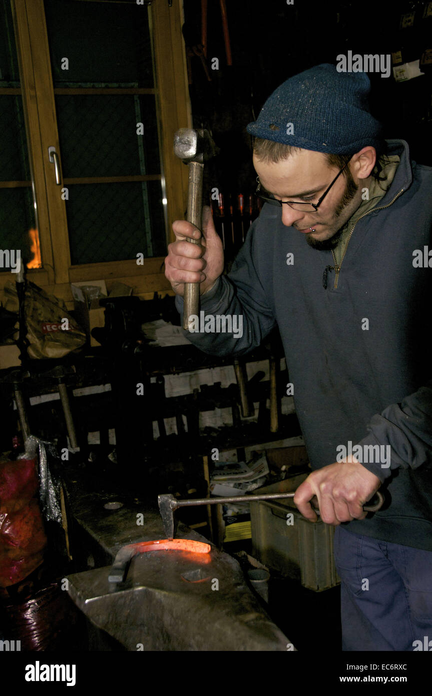 blacksmith working with sledge on redhot horseshoe Stock Photo - Alamy