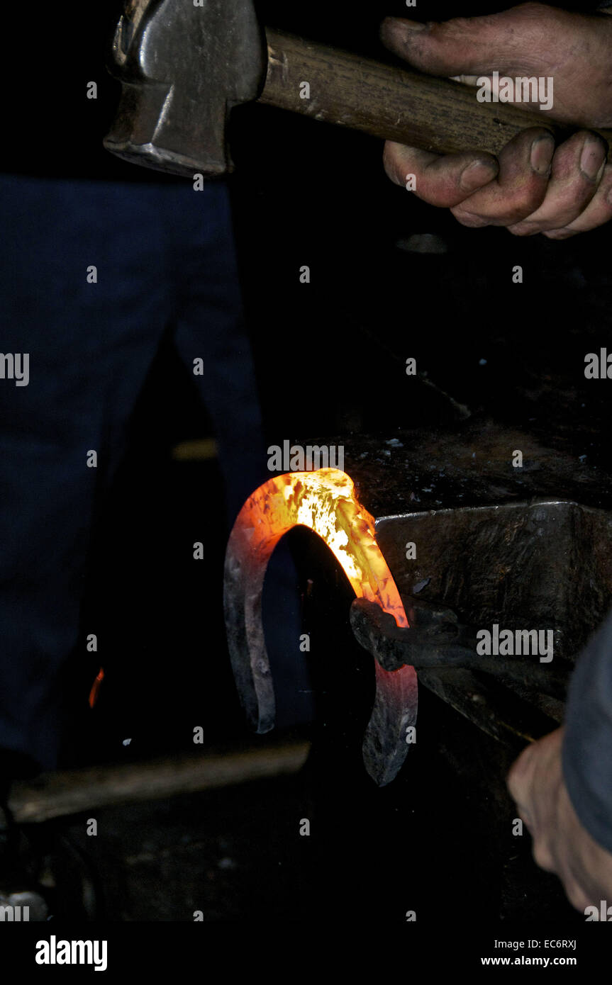 blacksmith working with sledge on redhot horseshoe Stock Photo - Alamy