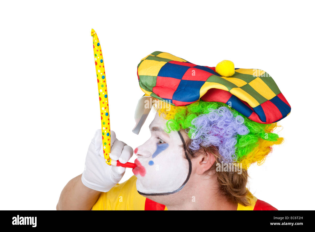 Clown with multicoloured cap blowing into a pipe Stock Photo - Alamy