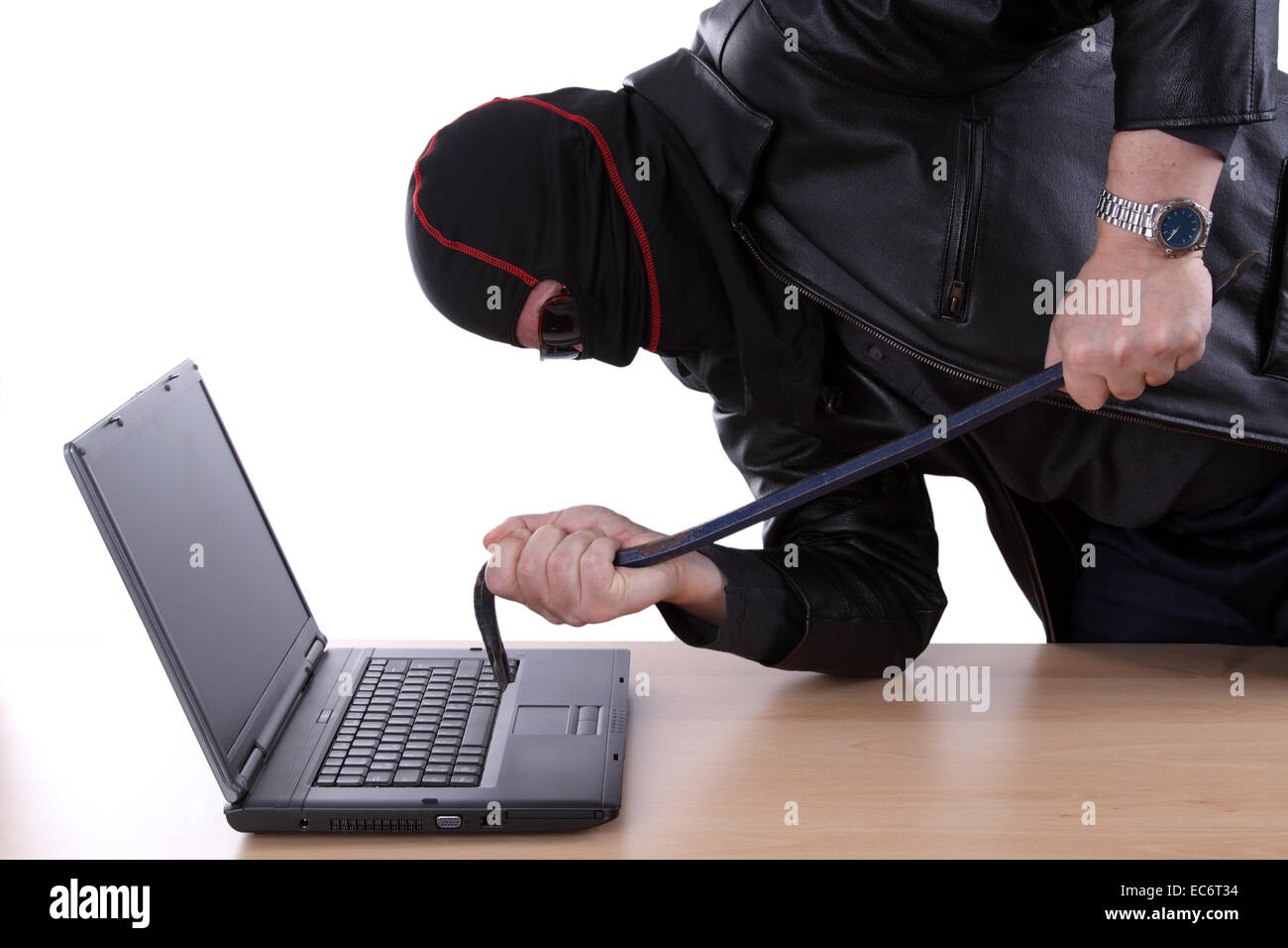 Masked man with crowbar breaking up a notebook Stock Photo - Alamy