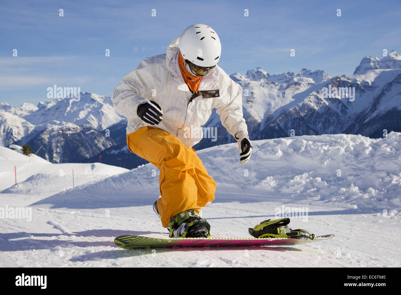 male snowboarder strapping on his snowboard Stock Photo - Alamy
