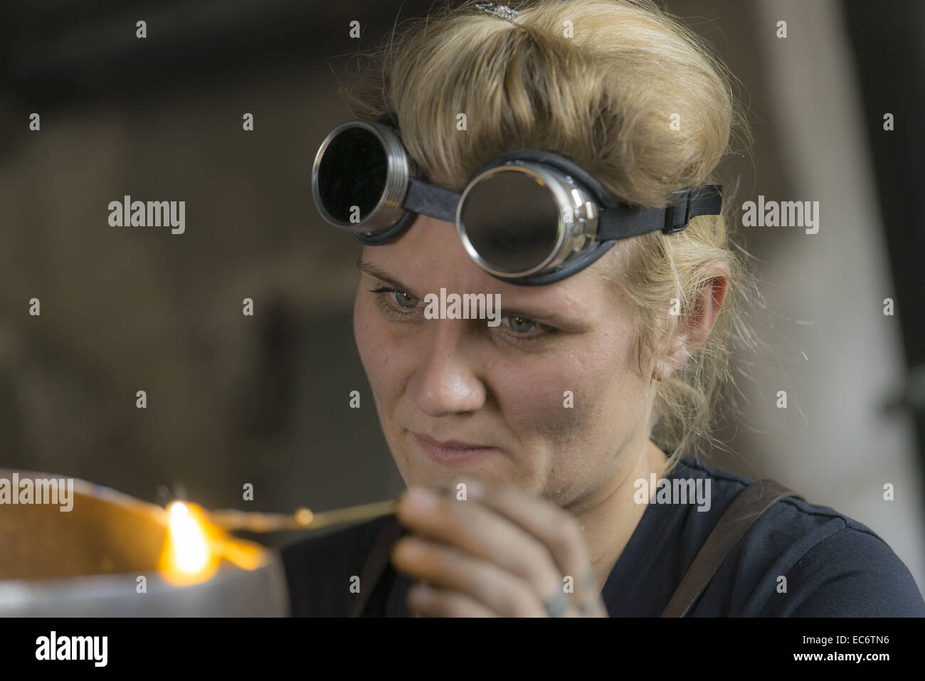 young female blacksmith with goggles, soldering metal Stock Photo - Alamy