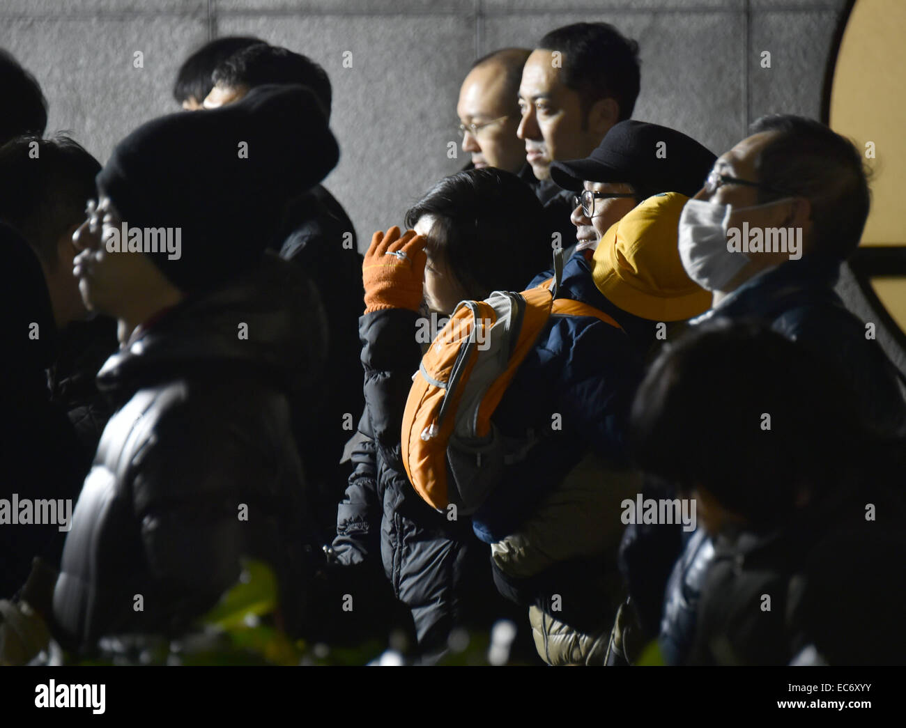 Tokyo, Japan - Braving the winter chill, a sizable crowd stops to ...