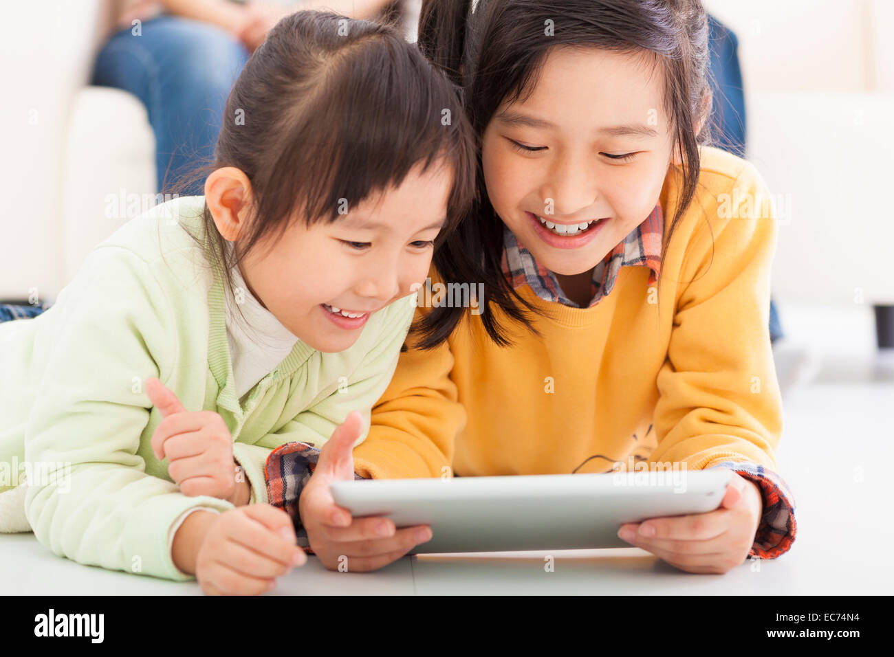 happy little girls using tablet computer Stock Photo - Alamy