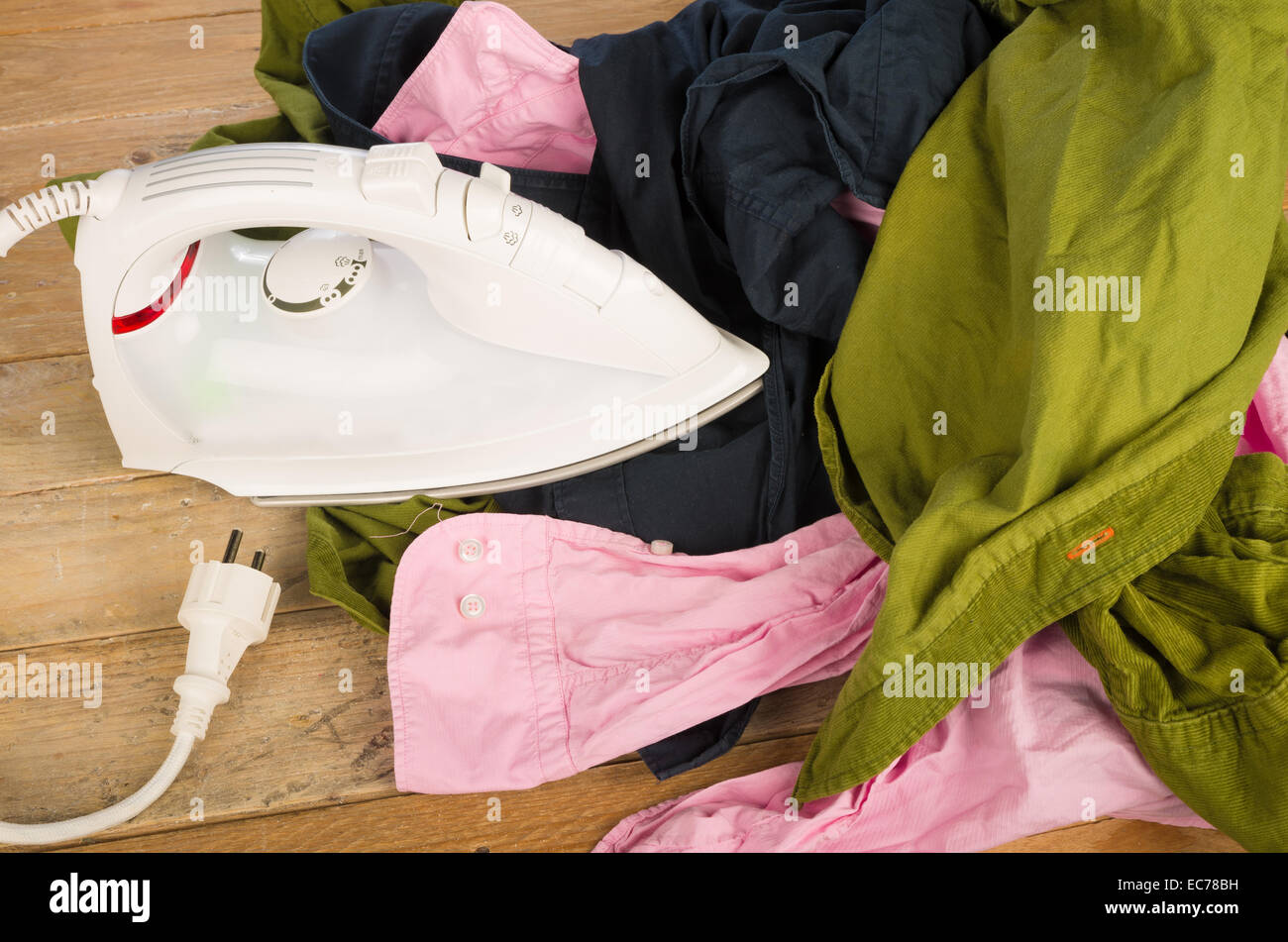 Iron next to a heap of creased and crumpled clothes Stock Photo - Alamy