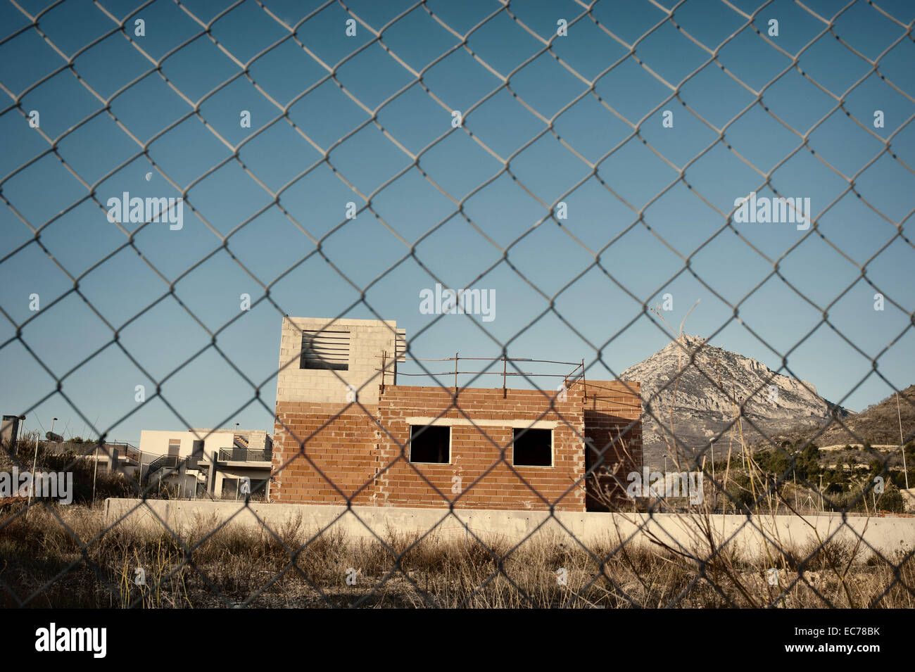 Fenced building site with abandoned unfinished houses Stock Photo - Alamy