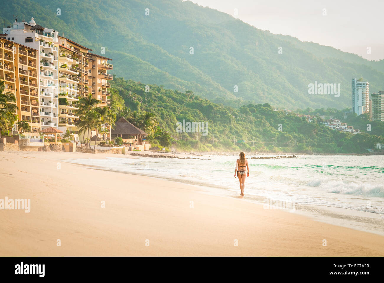 Mexico, Puerto Vallarta, woman wearing bikini walking at the Punta ...