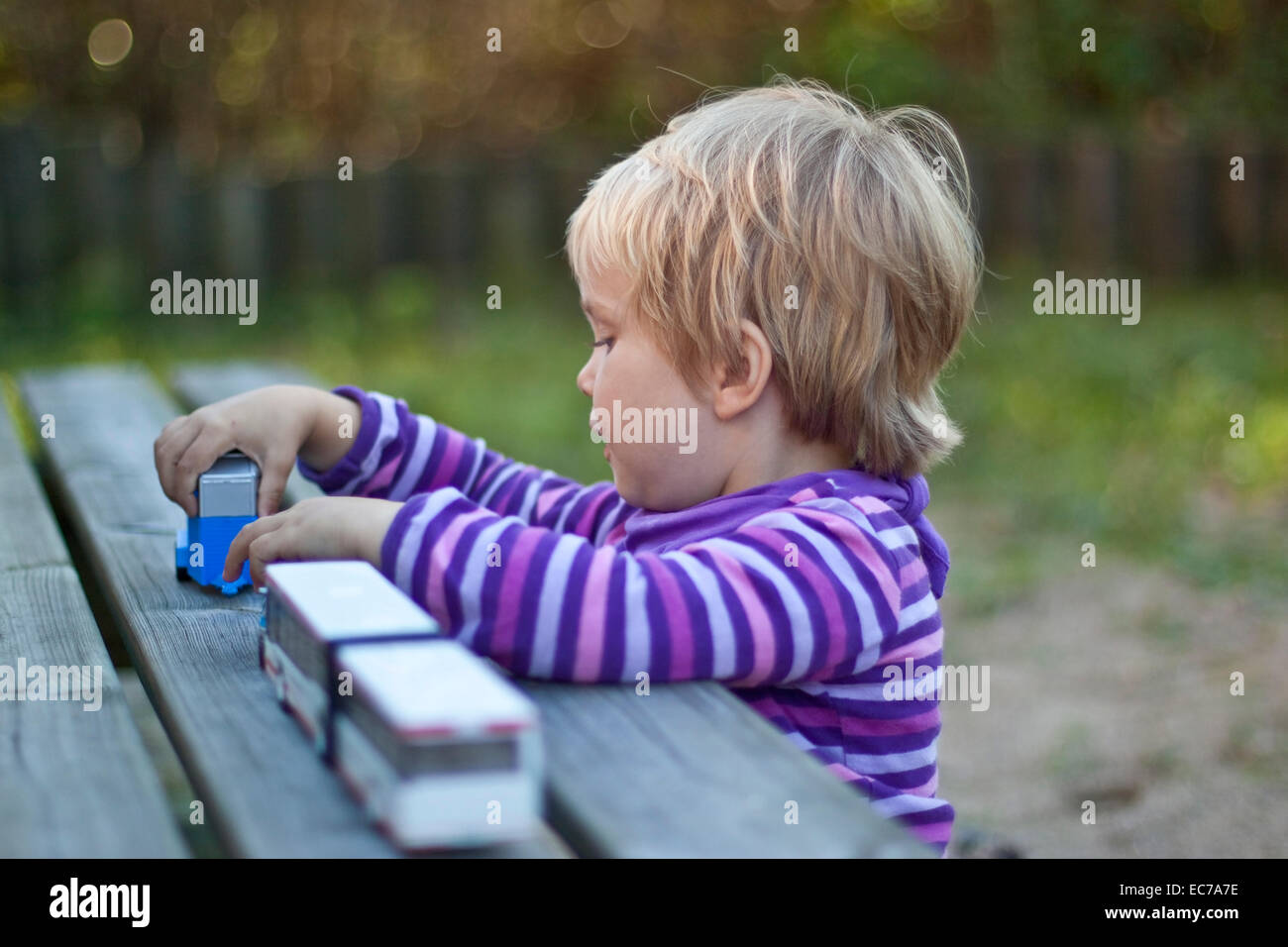Little girl playing with toy cars Stock Photo - Alamy