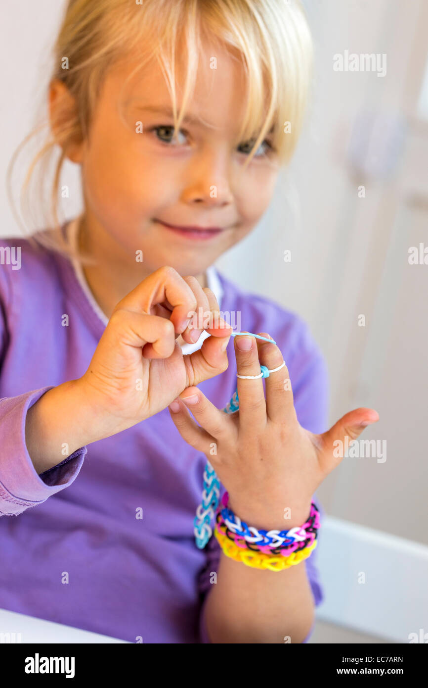 Portrait of little girl making loom bracelets Stock Photo - Alamy