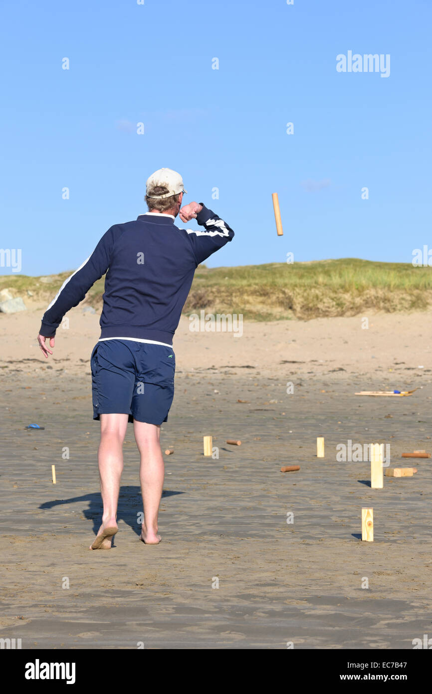 Man playing Kubb on the beach Stock Photo - Alamy