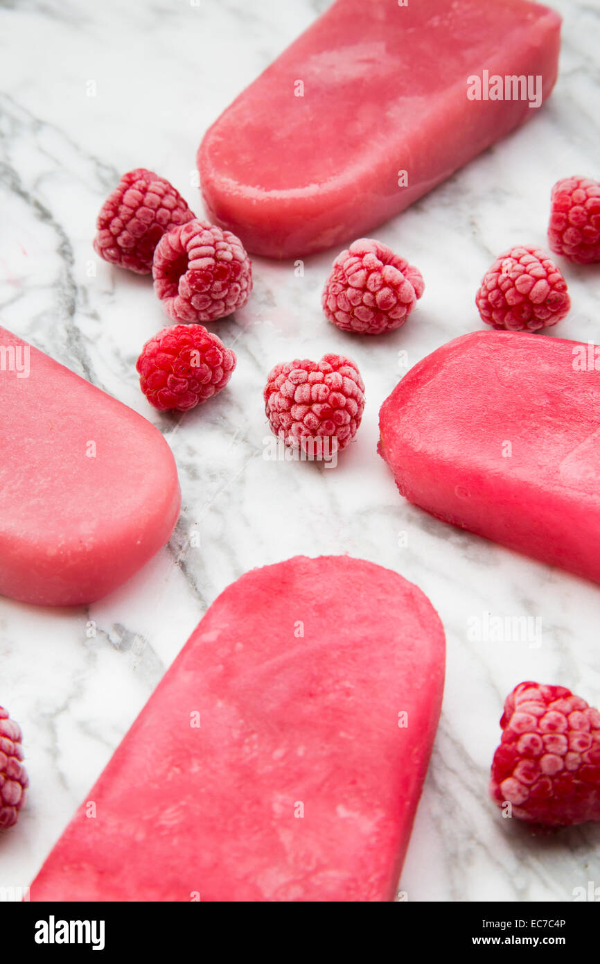 Raspberry ice lollies and frozen raspberries on marble Stock Photo - Alamy