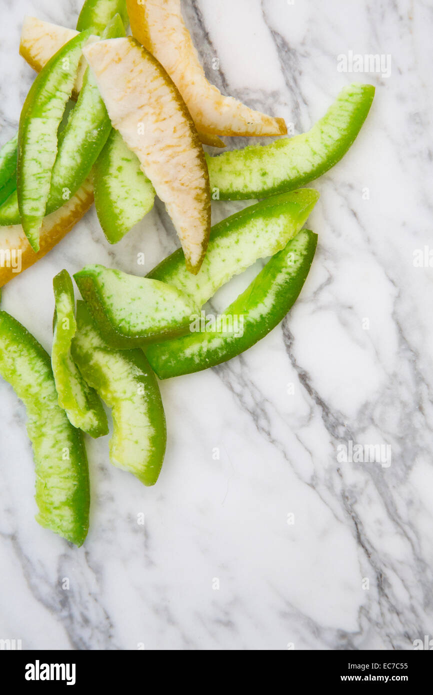 Slices of dried ripe and unripe citron, Citrus medica, on white marble ...