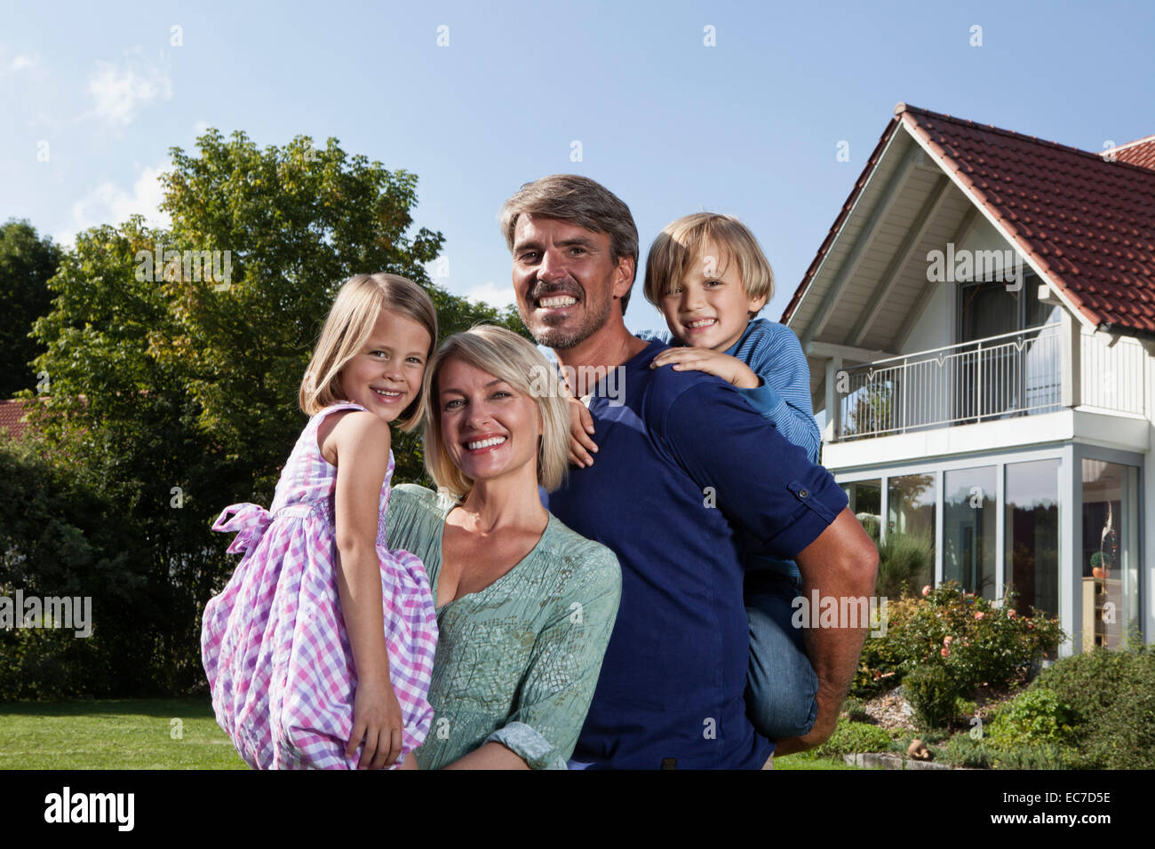 Portrait of happy family in garden Stock Photo - Alamy