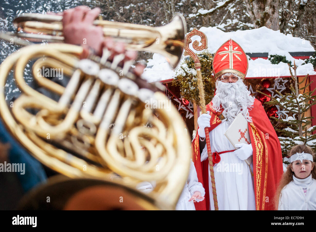 Musician playing horn with angel and Santa Claus in background Stock ...