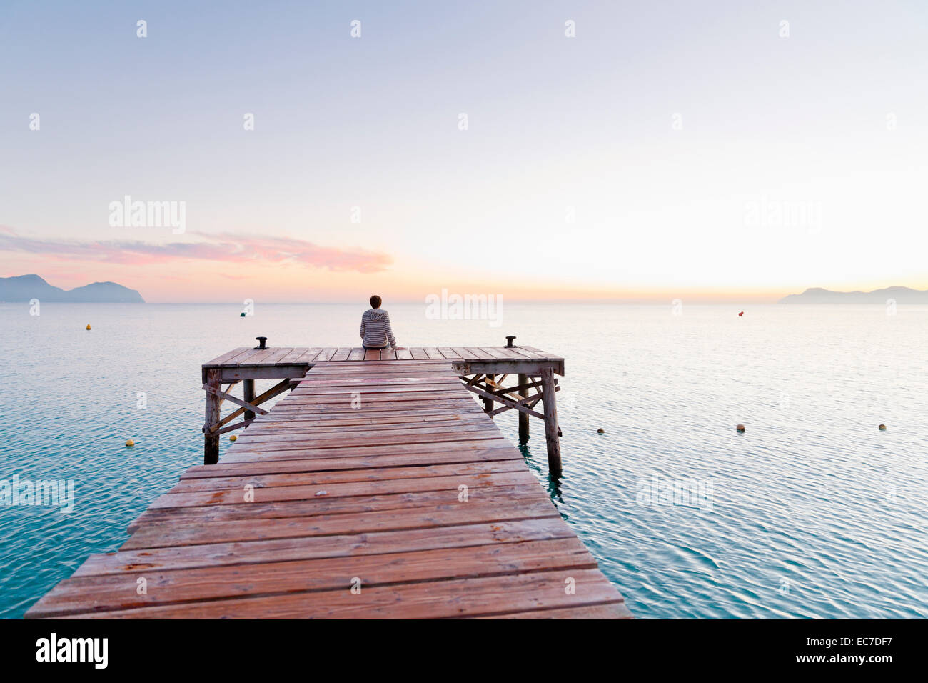 Spain, Balearic Islands, Majorca, one teenage boy sitting on a jetty in ...