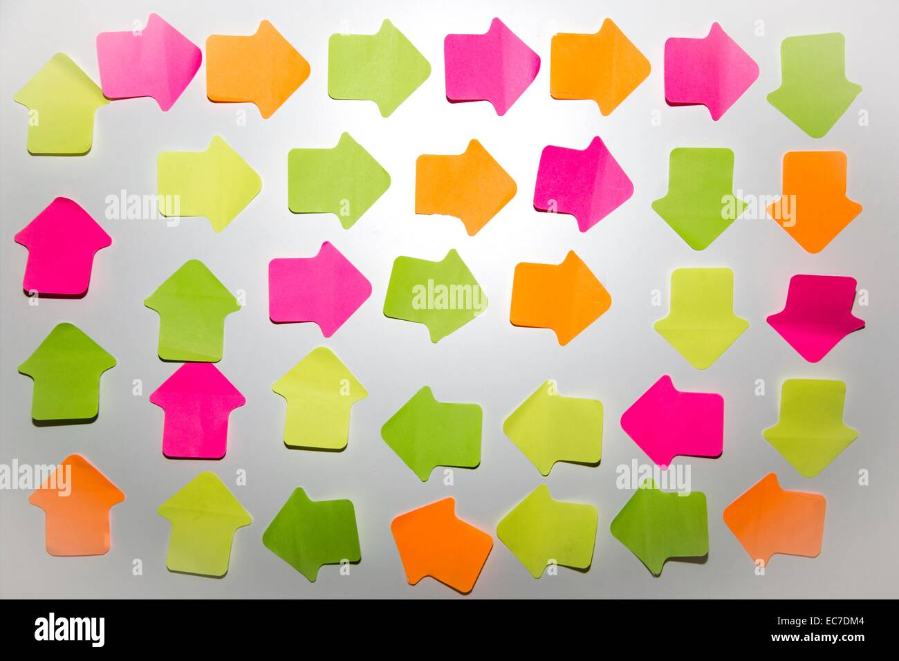Coloured arrow shaped adhesive notes on white wall Stock Photo - Alamy