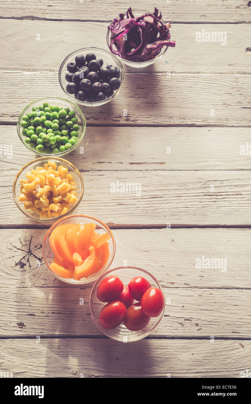 Glass bowls with different raw vegetables rainbow-coloured arranged ...