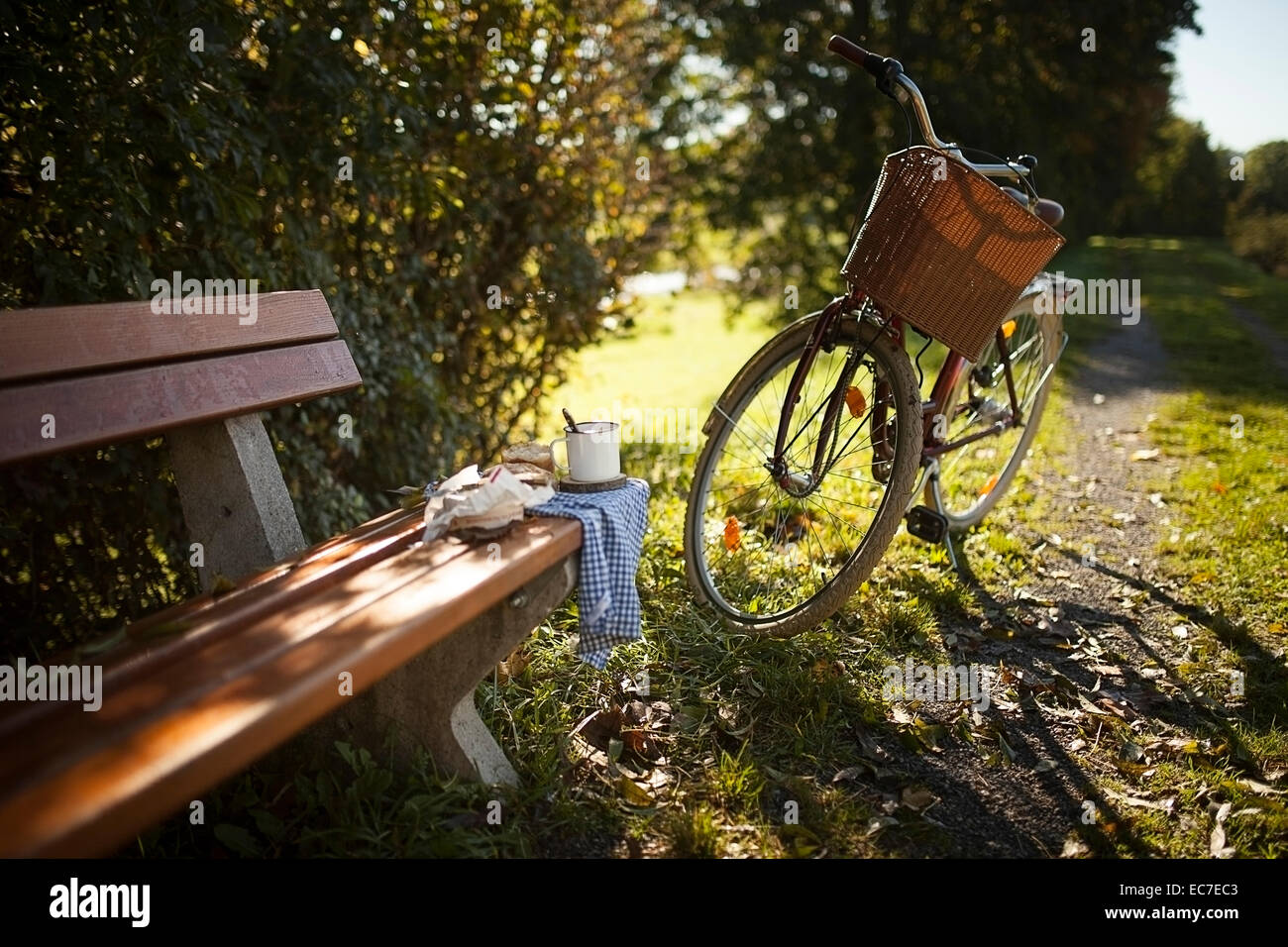 Bicycle next to on wooden bench Stock Photo - Alamy