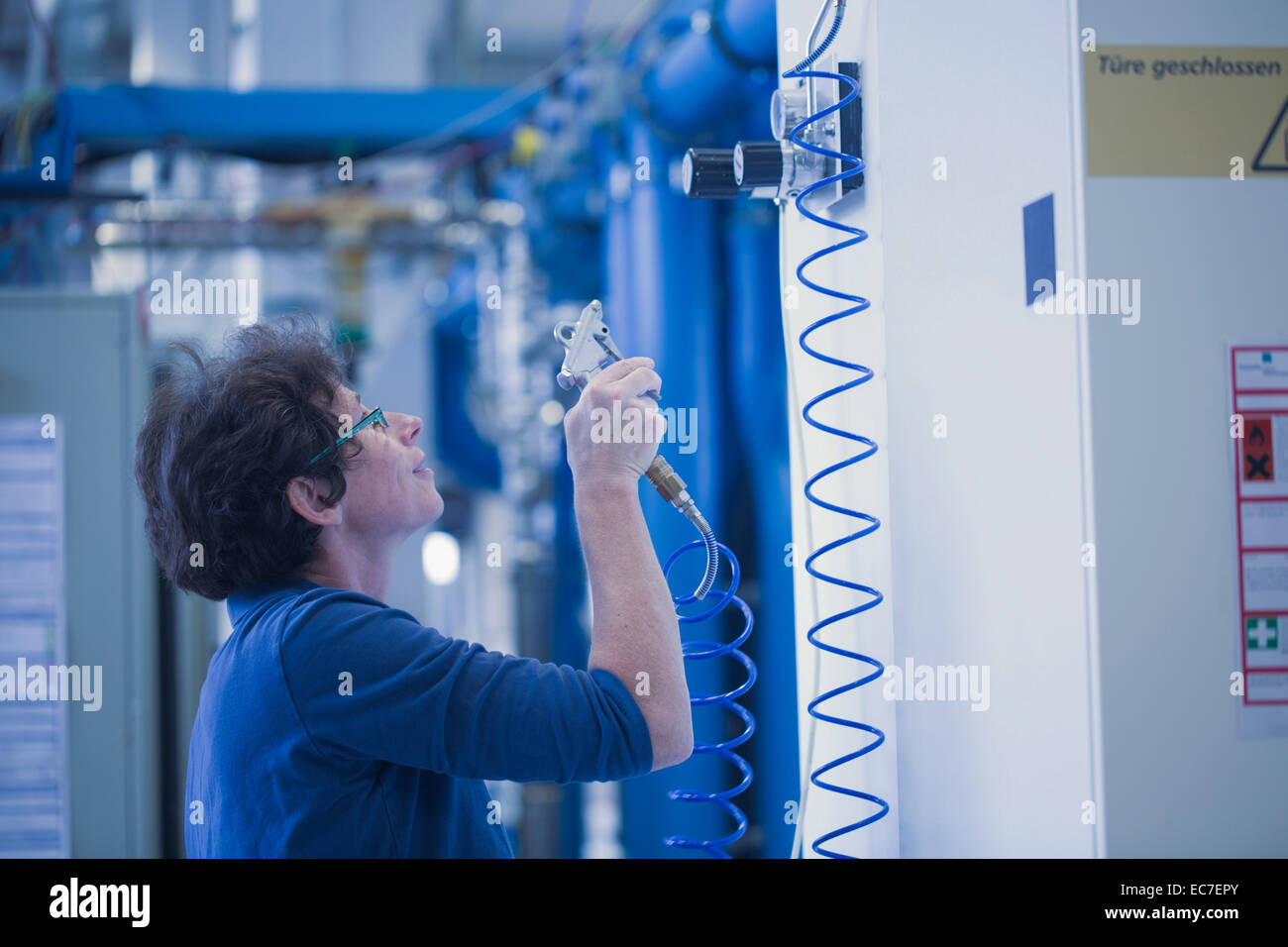 Female technical support specialist spraying with a tool in a technical ...