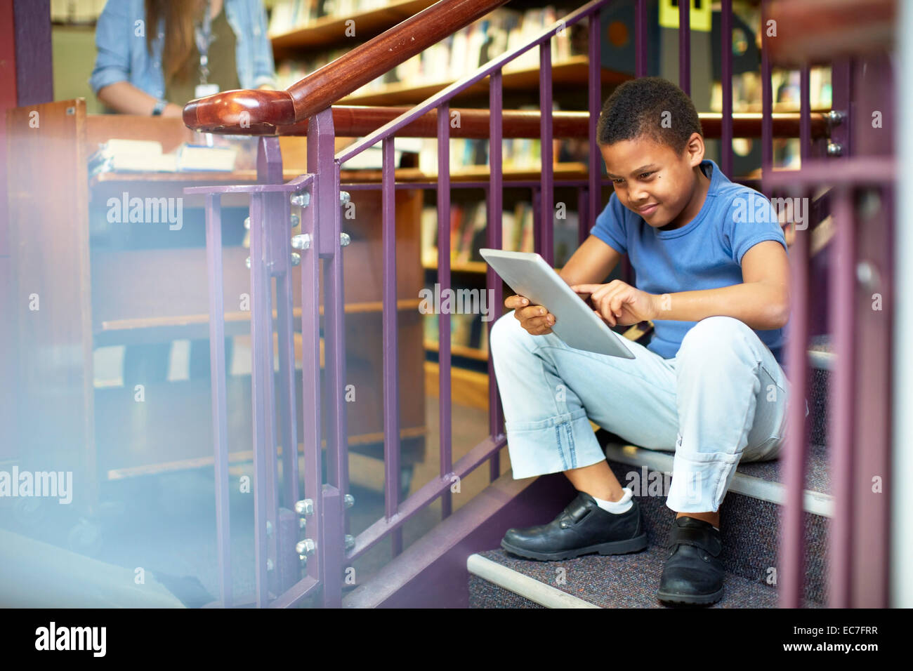 Boy using digital tablet in library Stock Photo - Alamy